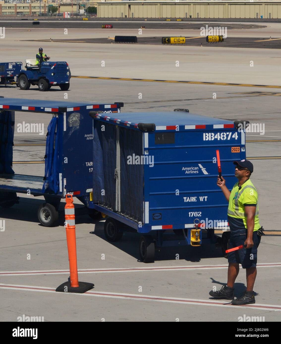 A ground crew member helps direct an American Airlines plane to its ...