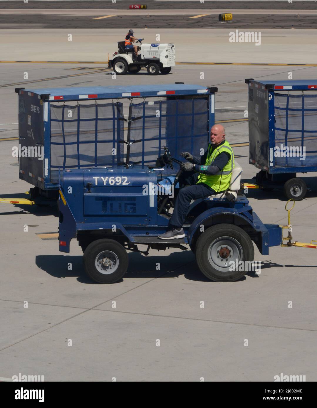 A ground crew worker transports passenger baggage from an aircraft to ...