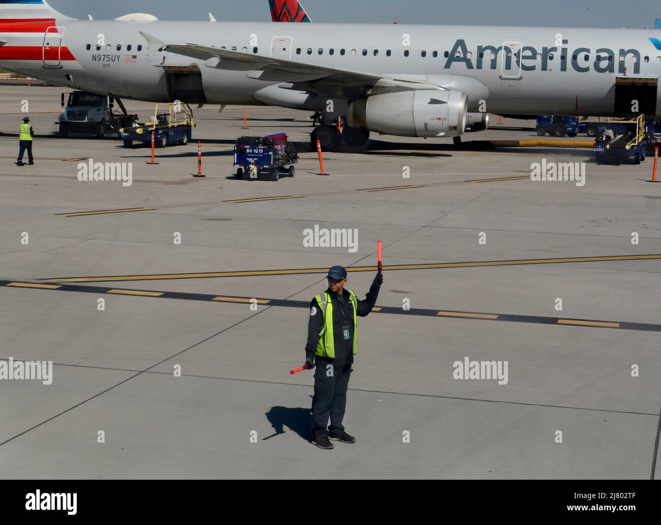 Ground crew workers guide an American Airlines Airbus A321 passenger ...