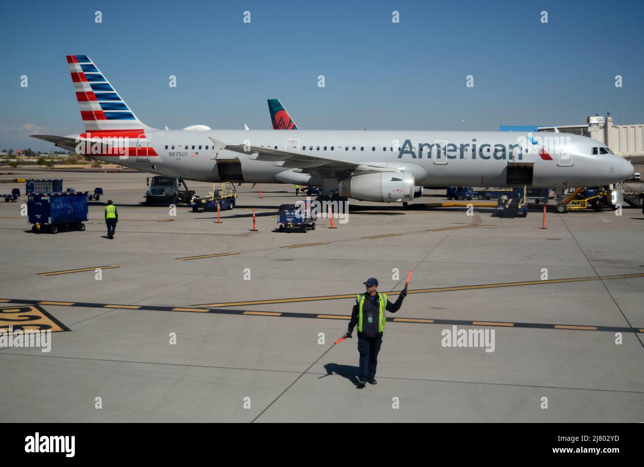 Ground crew workers guide an American Airlines Airbus A321 passenger ...