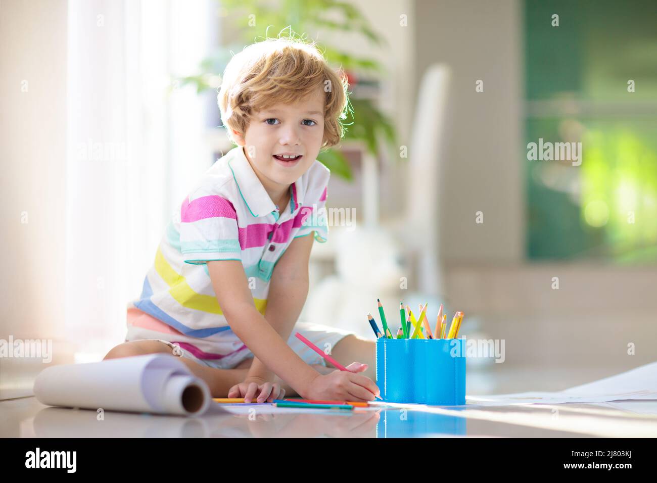 Child drawing lying on the floor. Kid painting rainbow. Online remote ...