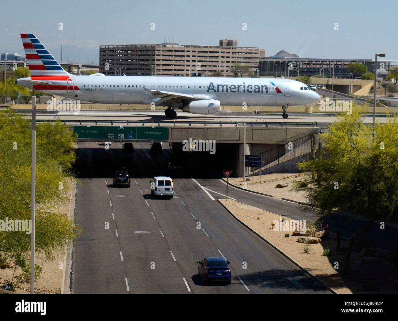 An American Airlines passenger plane crosses over a highway overpass as ...