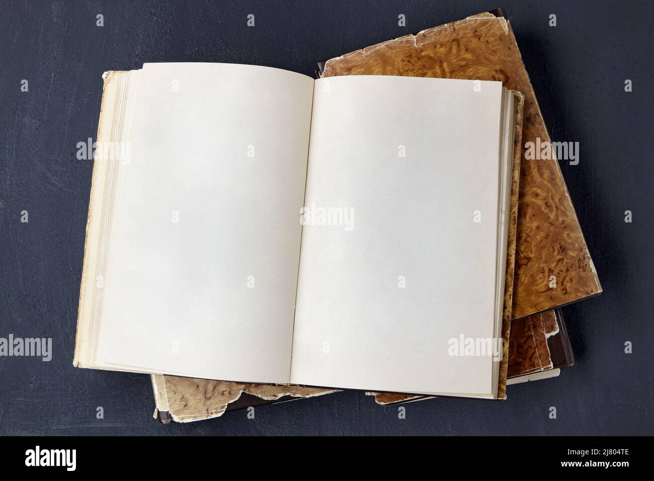 Open vintage book in a super cover on a stack of old dilapidated books ...