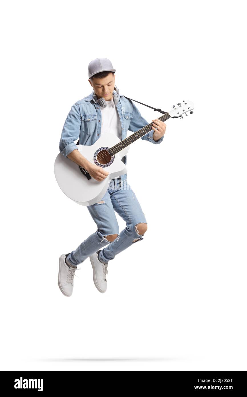 Energetic guy jumping and playing an acoustic guitar isolated on white ...