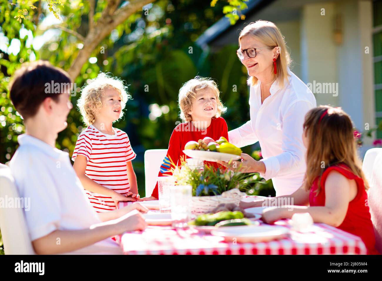 Family eating outdoors. Garden summer fun. Barbecue in sunny backyard ...