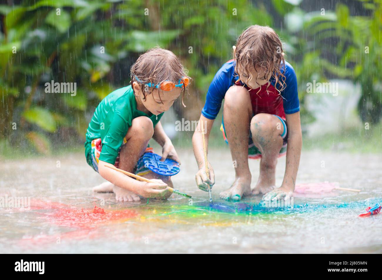 Kids playing in the rain. Chalk drawing fun. Art and crafts for young ...