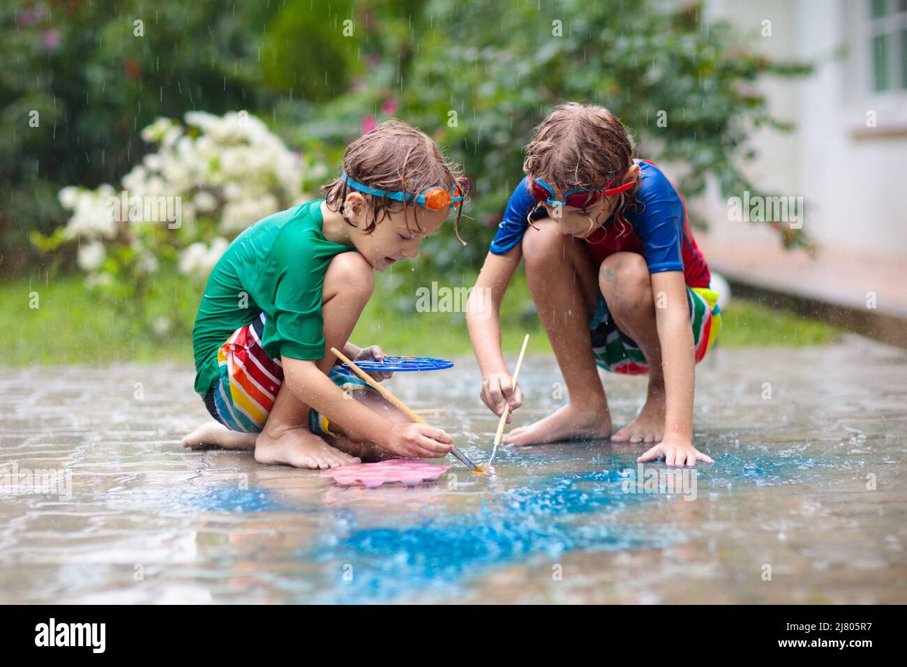 Kids playing in the rain. Chalk drawing fun. Art and crafts for young ...