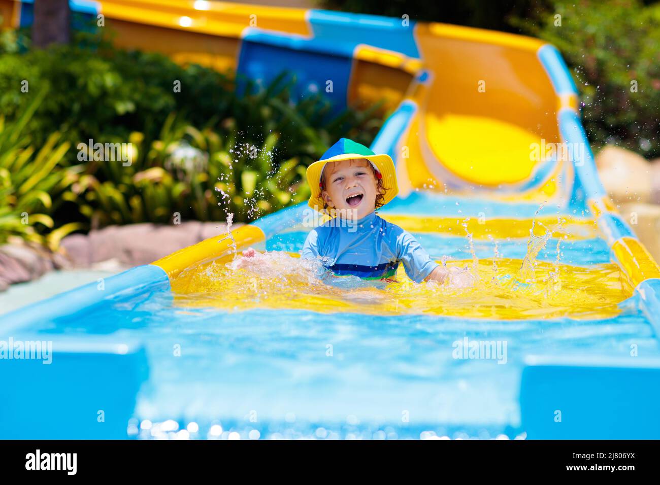 Kids on water slide in aqua park. Children having fun on water slides ...