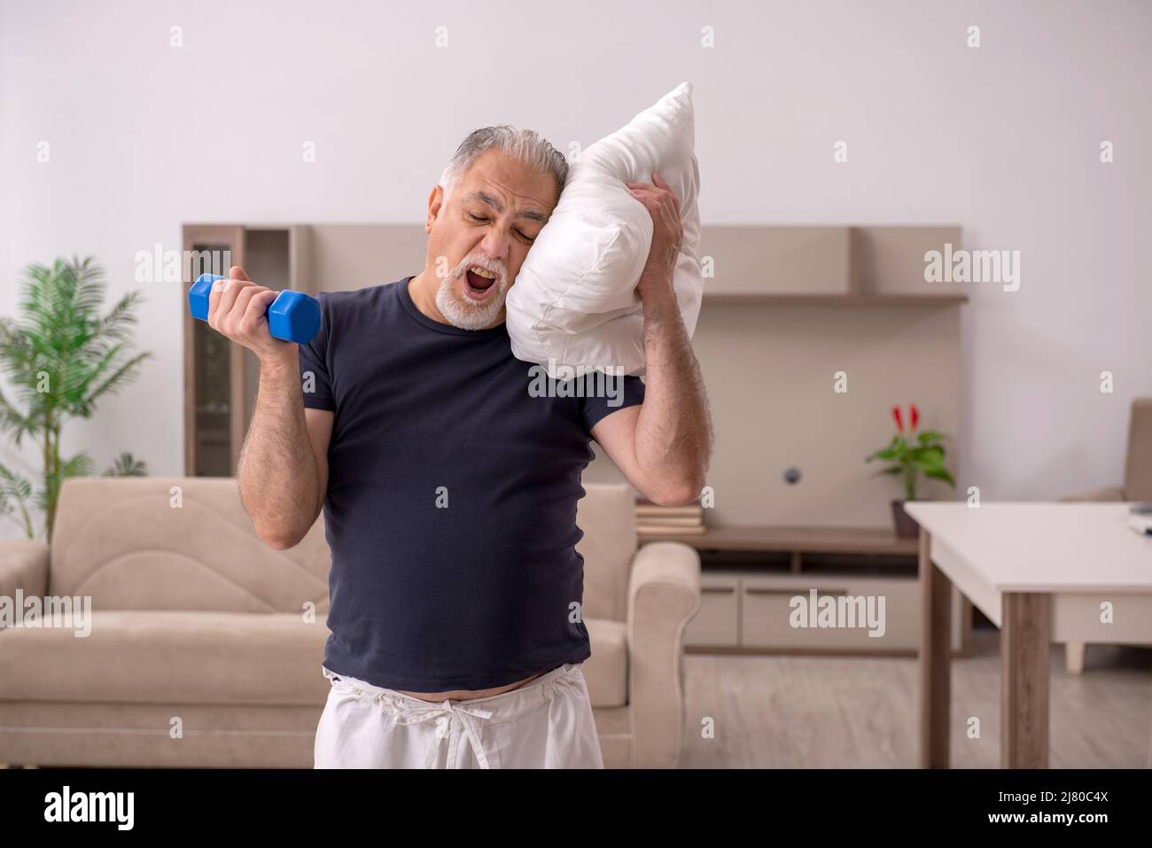 Old man doing sport exercises indoors Stock Photo - Alamy