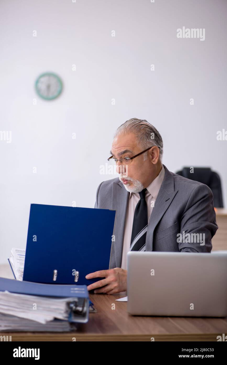 Old male boss sitting at workplace Stock Photo - Alamy