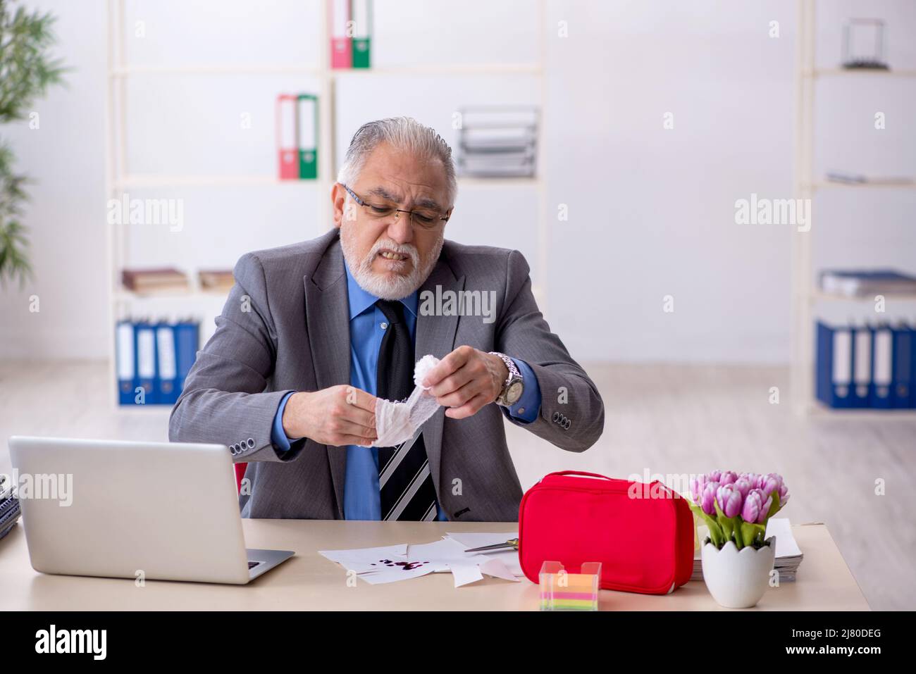 Old businessman employee cutting his hand at workplace Stock Photo - Alamy