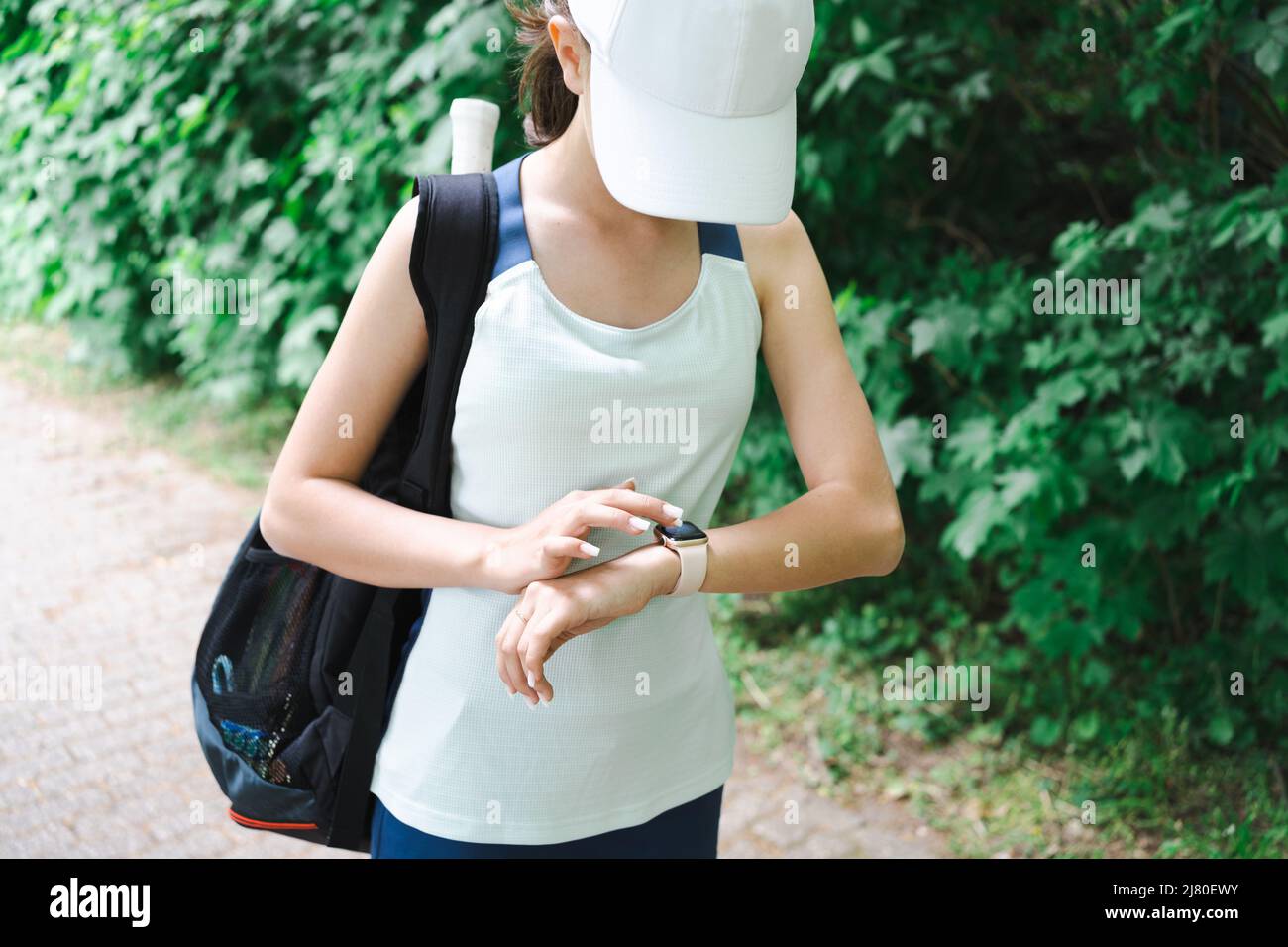 Girl is going to play tennis and watching on smartwatch. Waiting for a ...