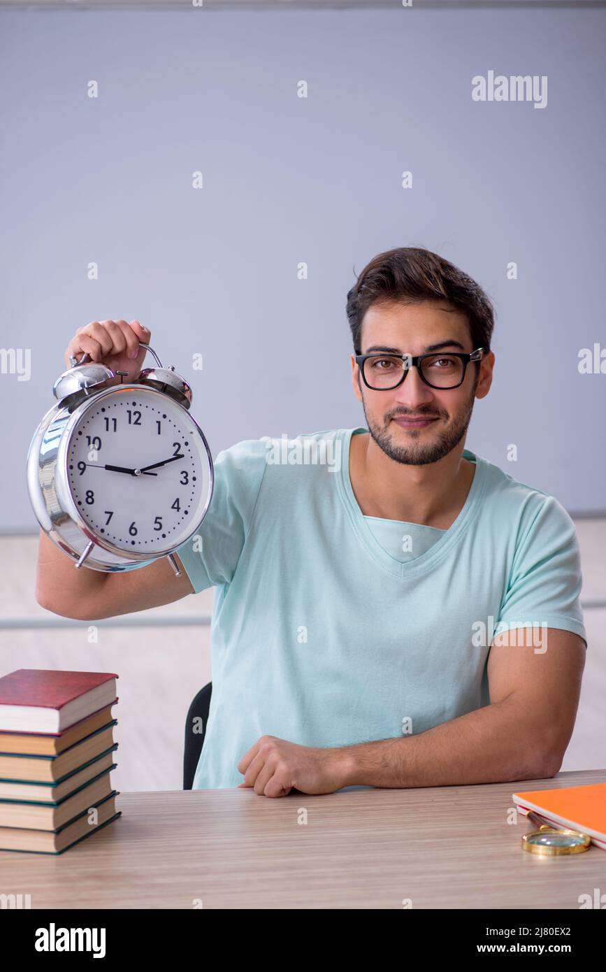 Young student in time management concept in the classroom Stock Photo ...