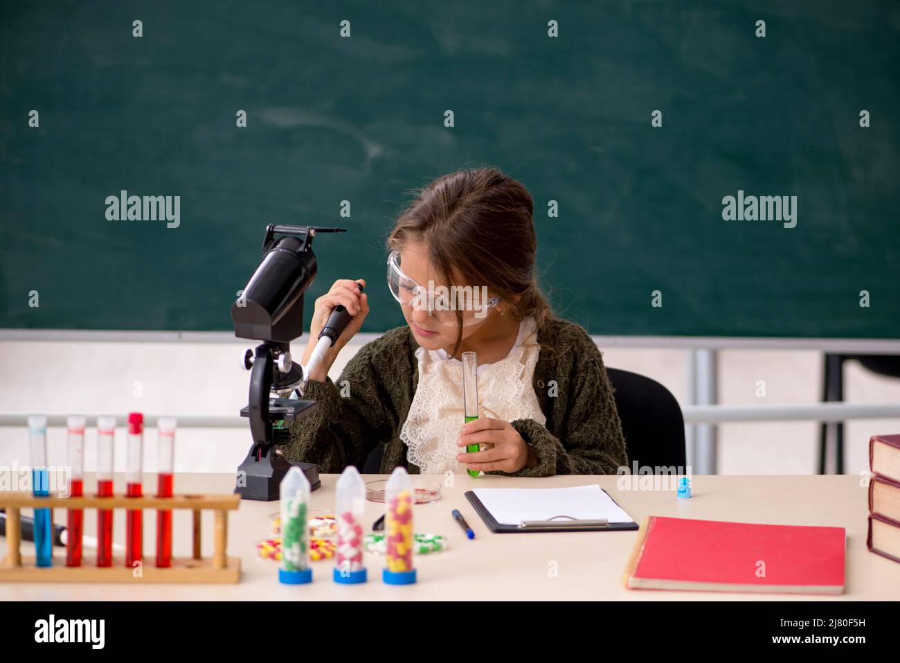 Young small girl chemist in the classroom Stock Photo - Alamy