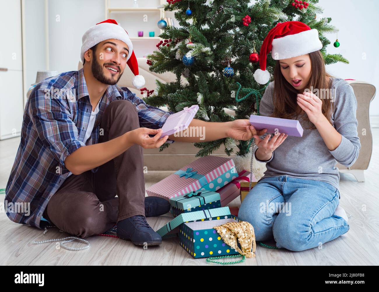 The girlfriend and boyfriend opening christmas gifts Stock Photo - Alamy