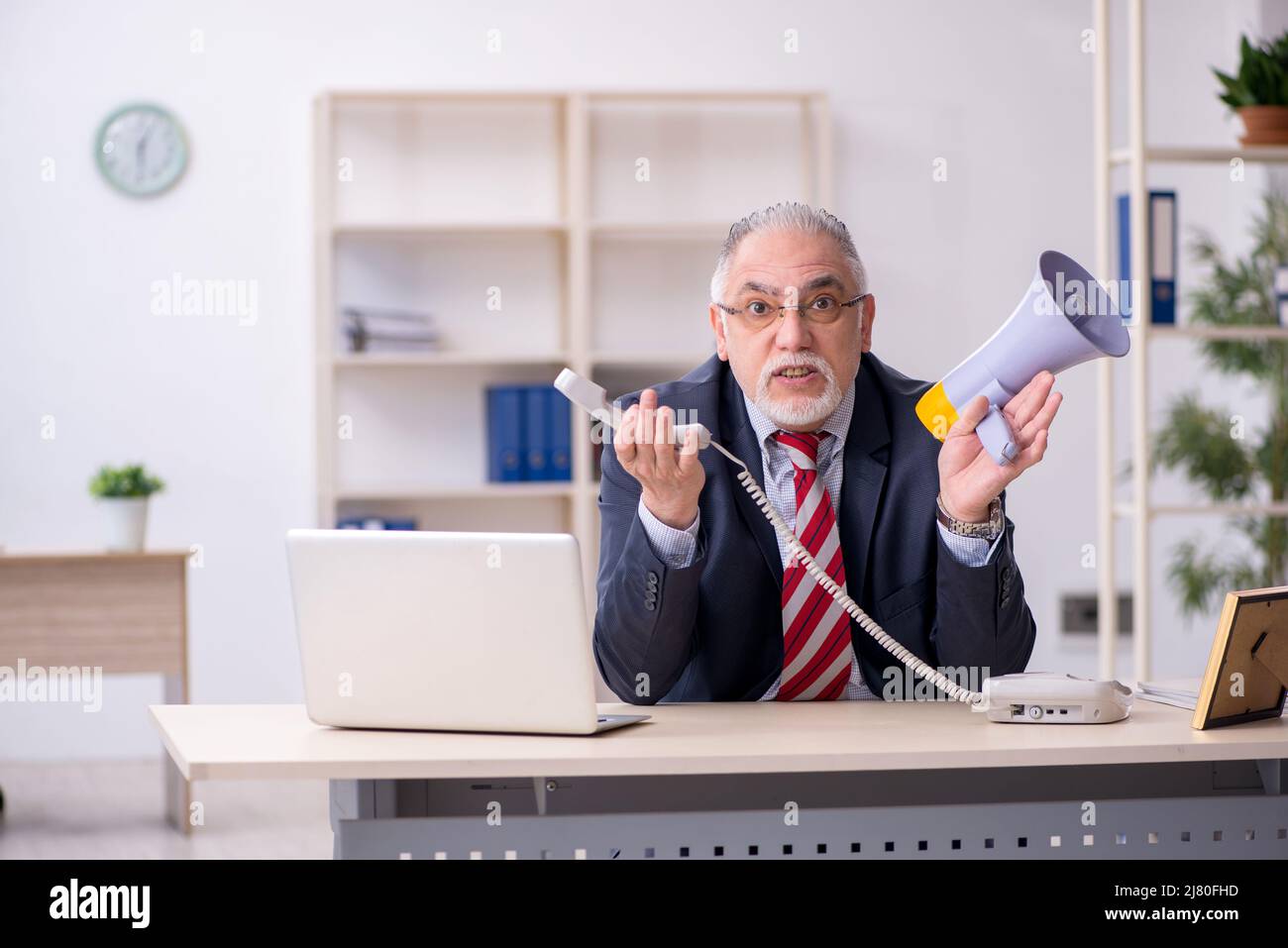 Angry boss holding megaphone in the office Stock Photo - Alamy
