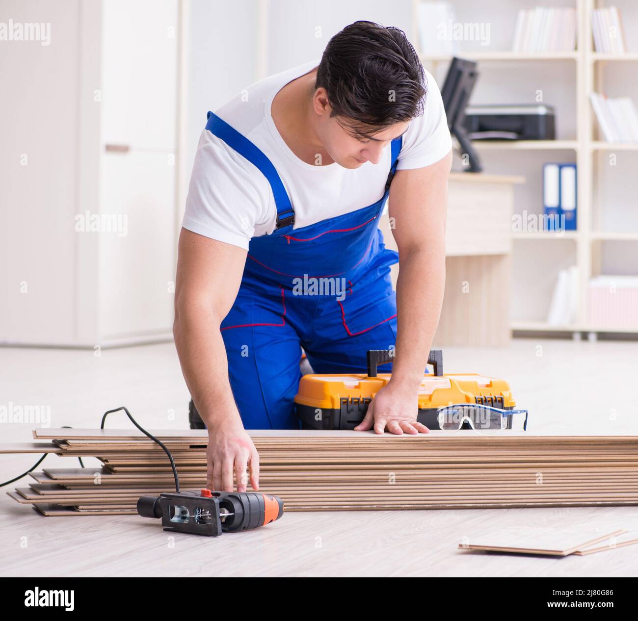 The young worker working on floor laminate tiles Stock Photo - Alamy