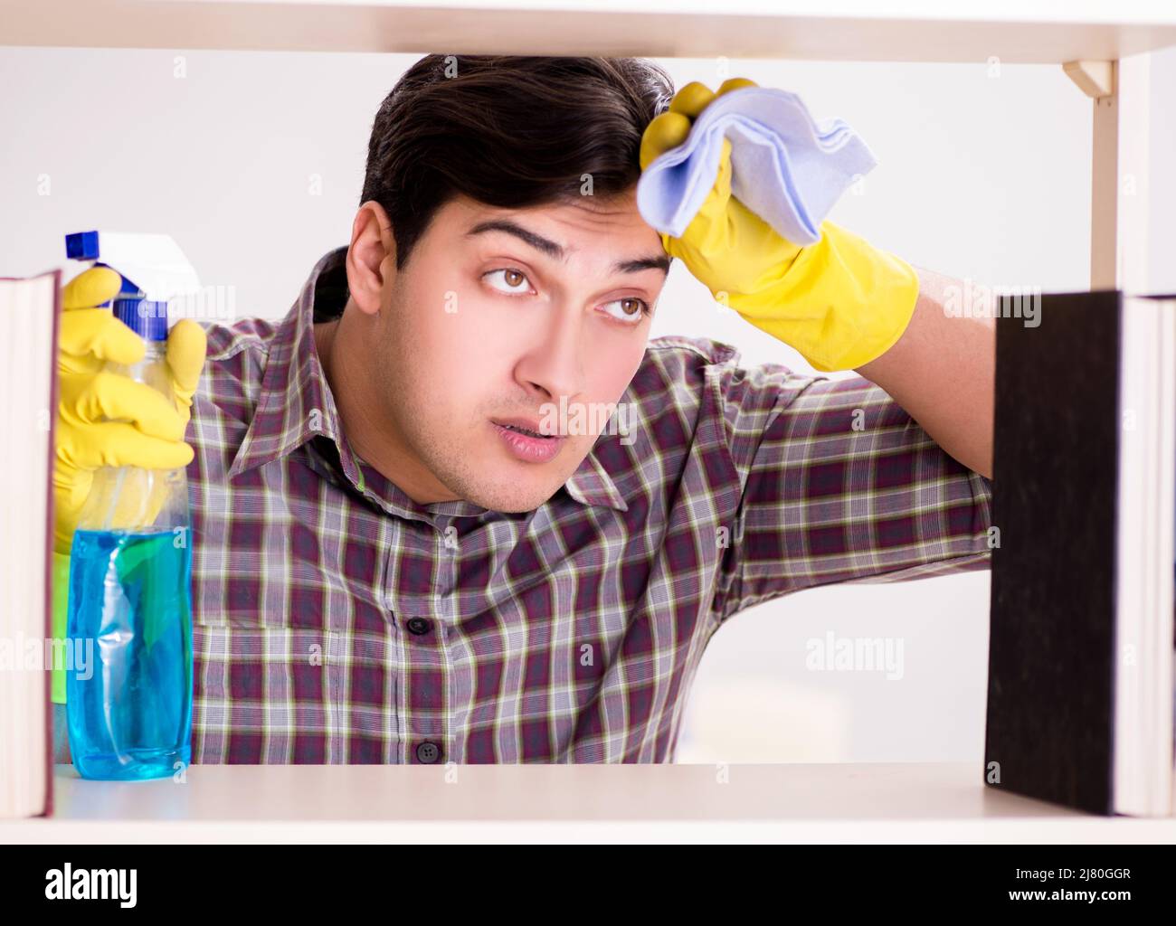 The man cleaning dust from bookshelf Stock Photo - Alamy