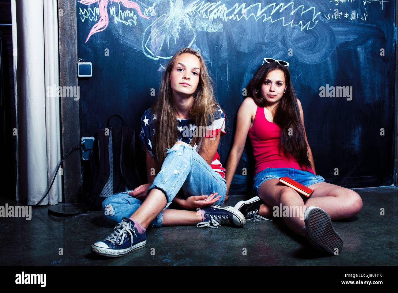 back to school after summer vacations, two teen girls in classroom with blackboard painted Stock ...