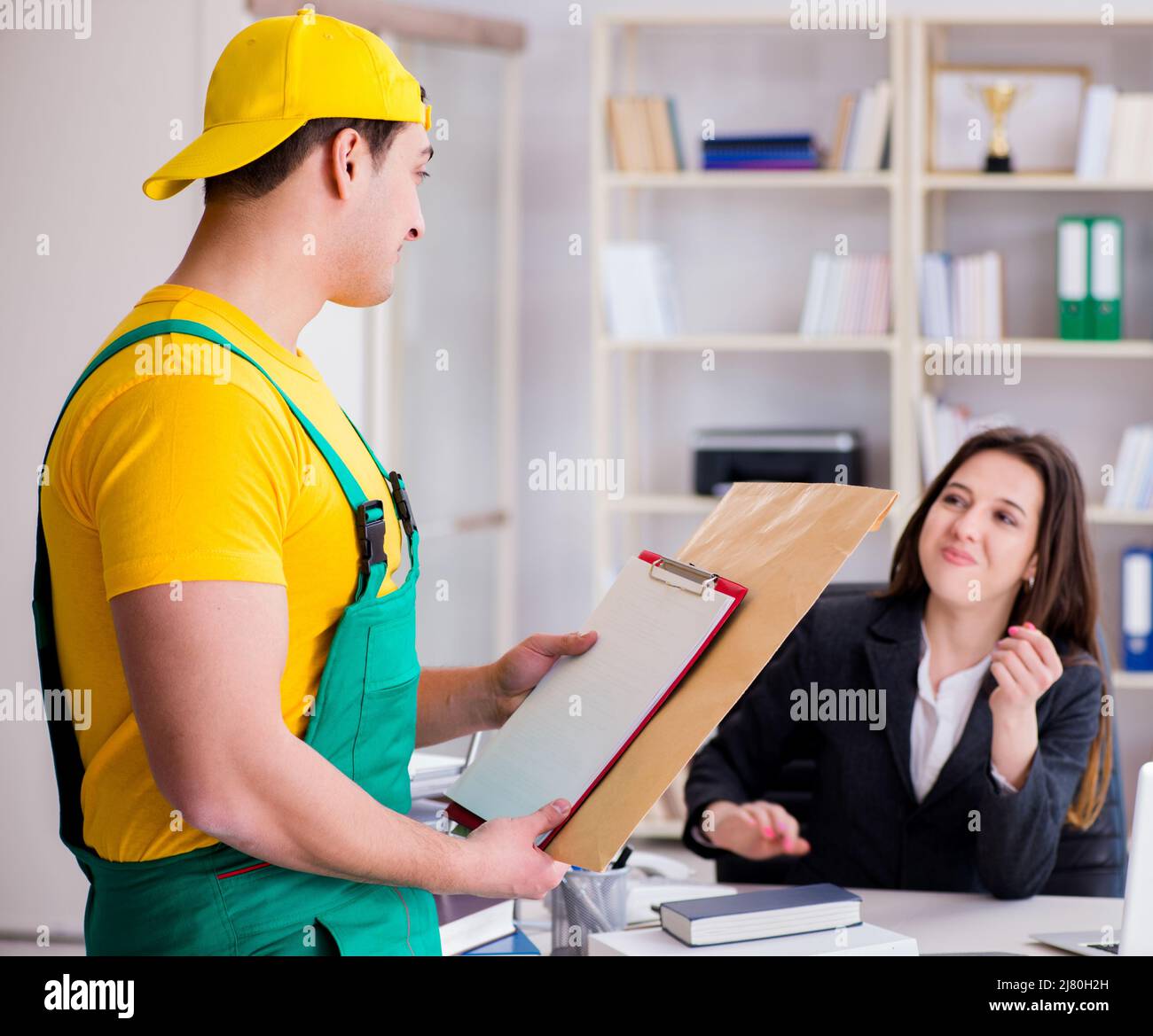 The postman delivering parcel to the office Stock Photo - Alamy