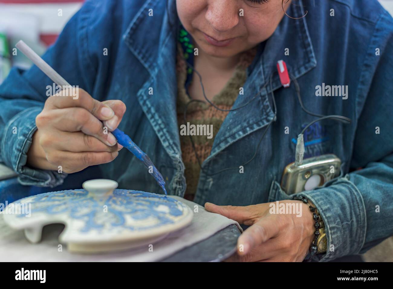 Mexican artisan painting the talavera patterns on a pottery piece Stock ...