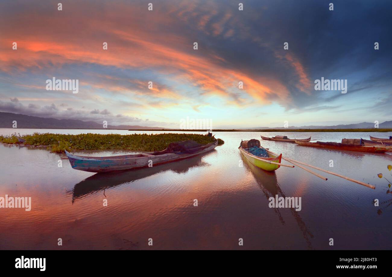 Traditional wooden boats anchored in Limboto Lake at sunset, Gorontalo ...