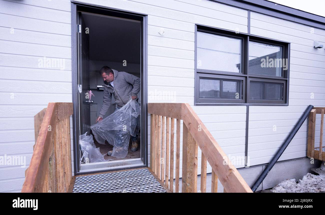 Pascal Landry pulls the plastic off of a new door on a construction ...