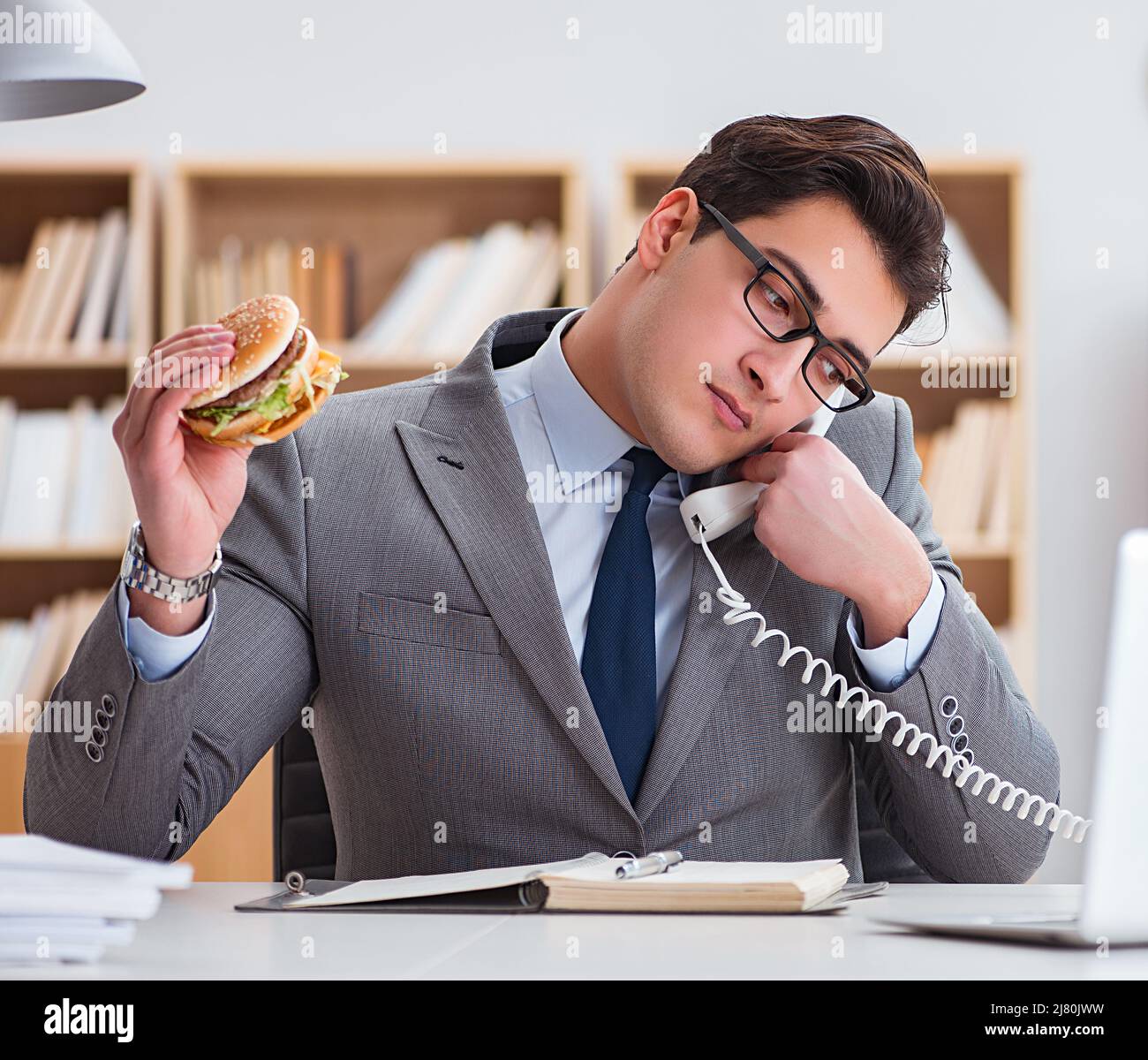 The hungry funny businessman eating junk food sandwich Stock Photo - Alamy