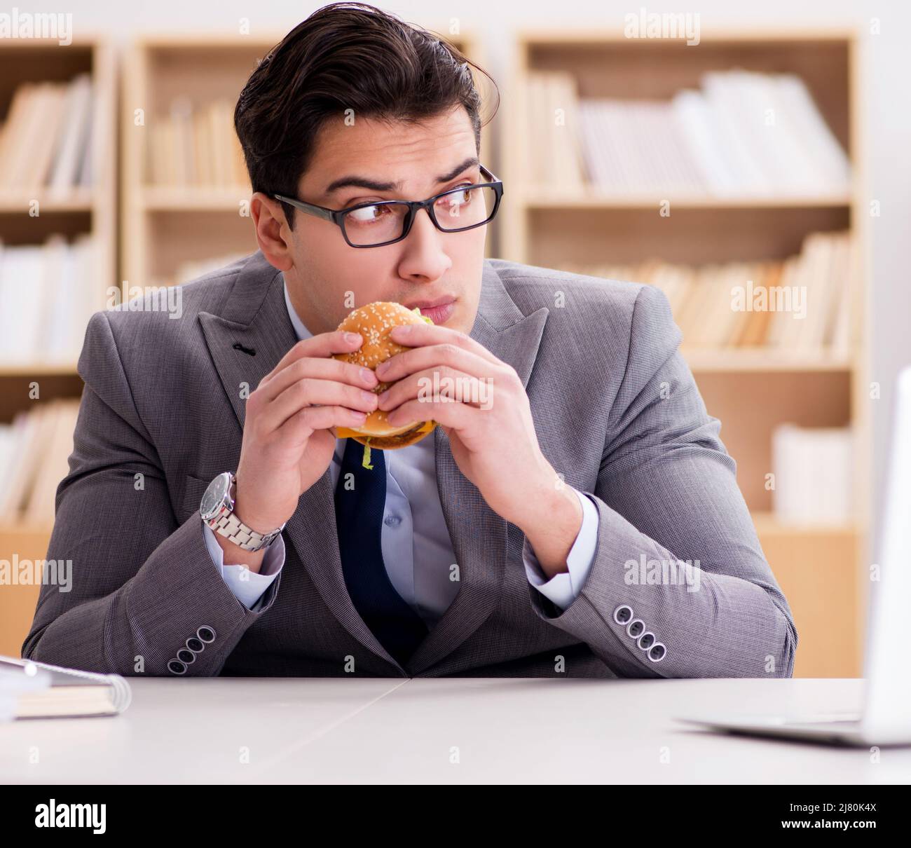 The hungry funny businessman eating junk food sandwich Stock Photo - Alamy