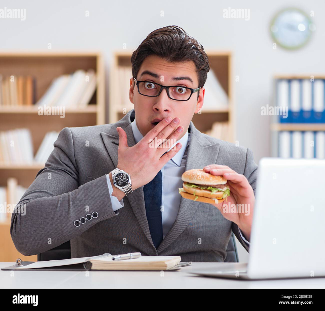 The hungry funny businessman eating junk food sandwich Stock Photo - Alamy