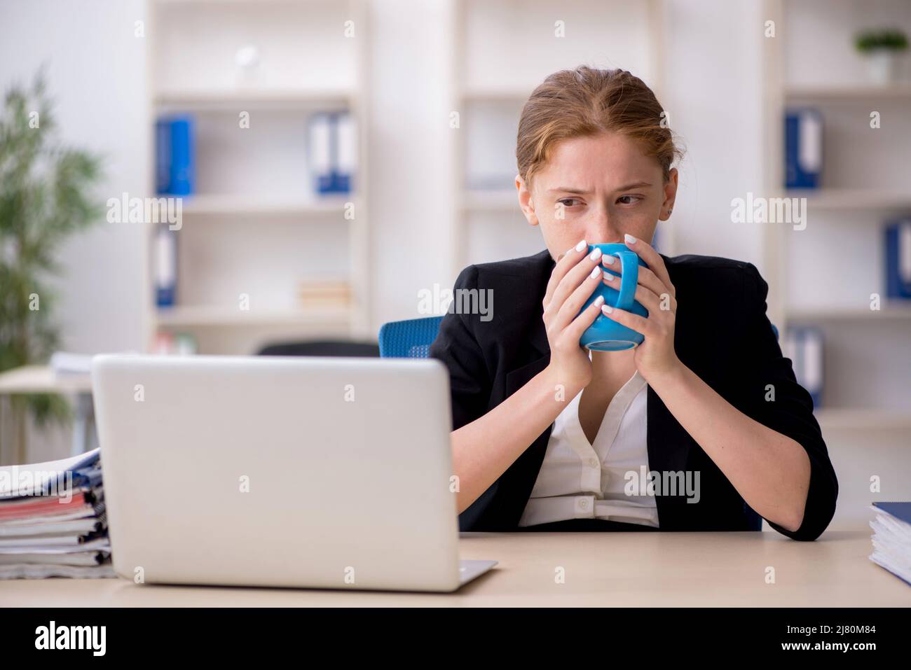 Female employee drinking coffee during break Stock Photo - Alamy