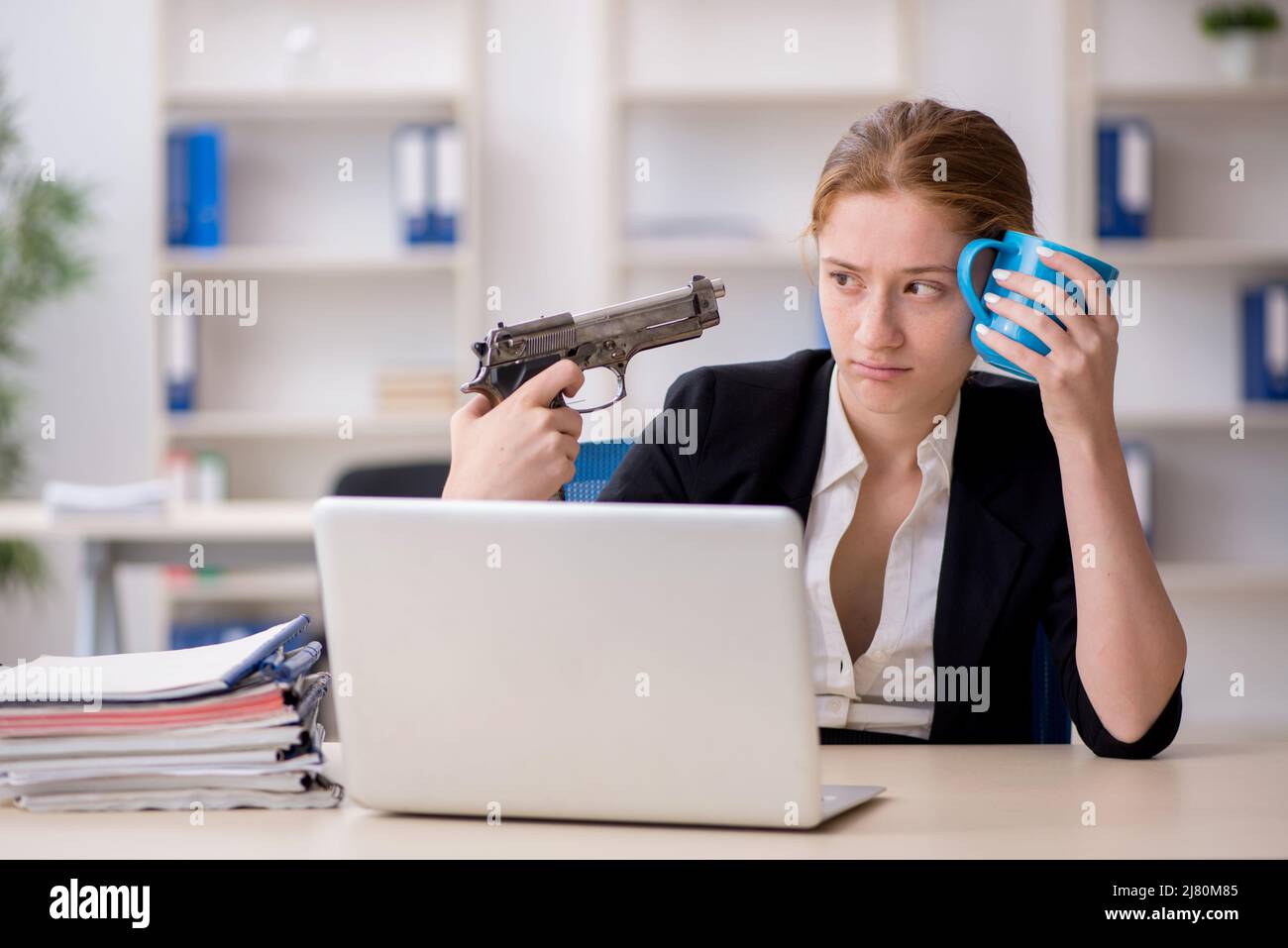 Female employee holding gun at workplace Stock Photo - Alamy