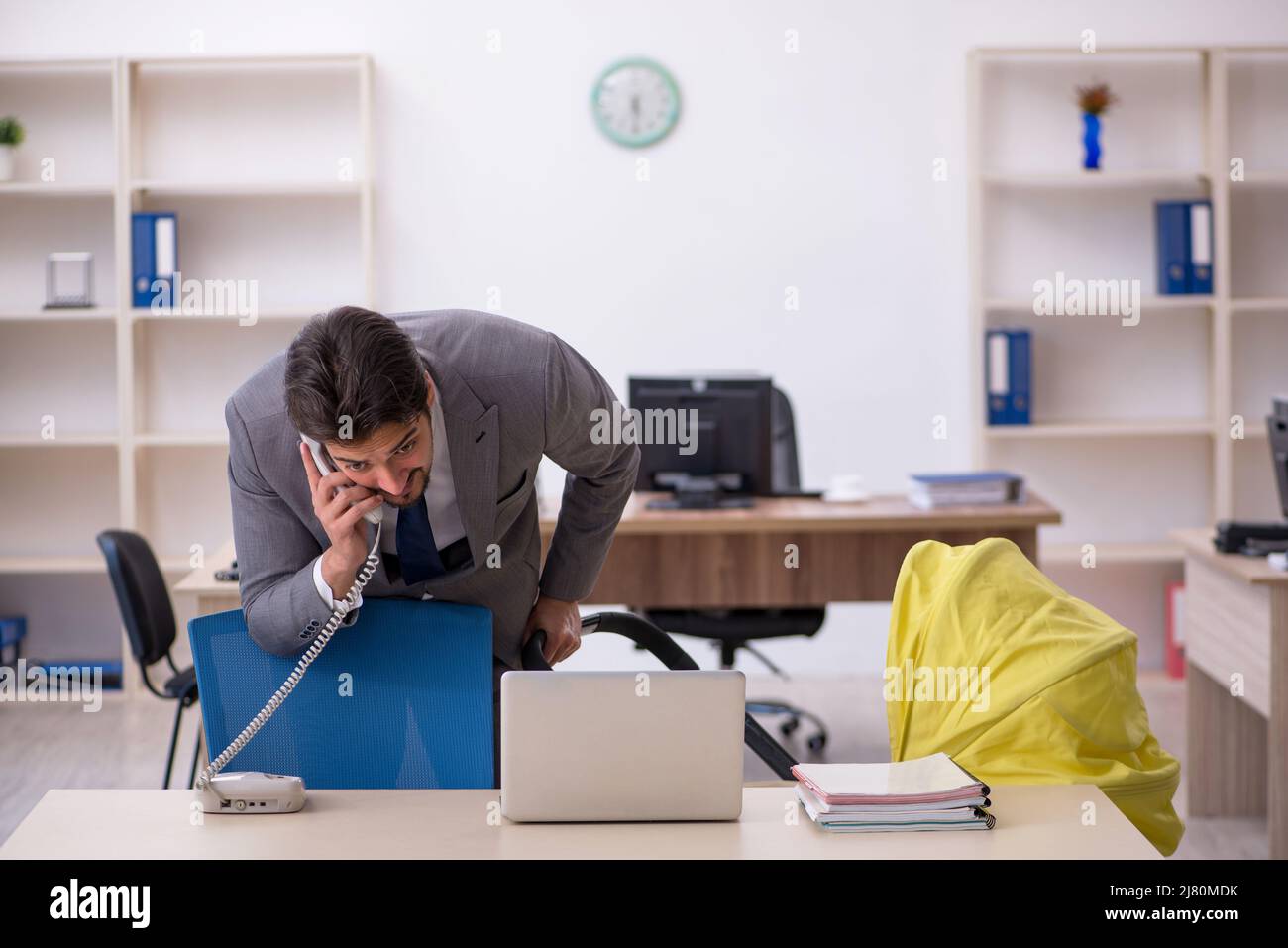 Young businessman employee looking after new born in the office Stock ...