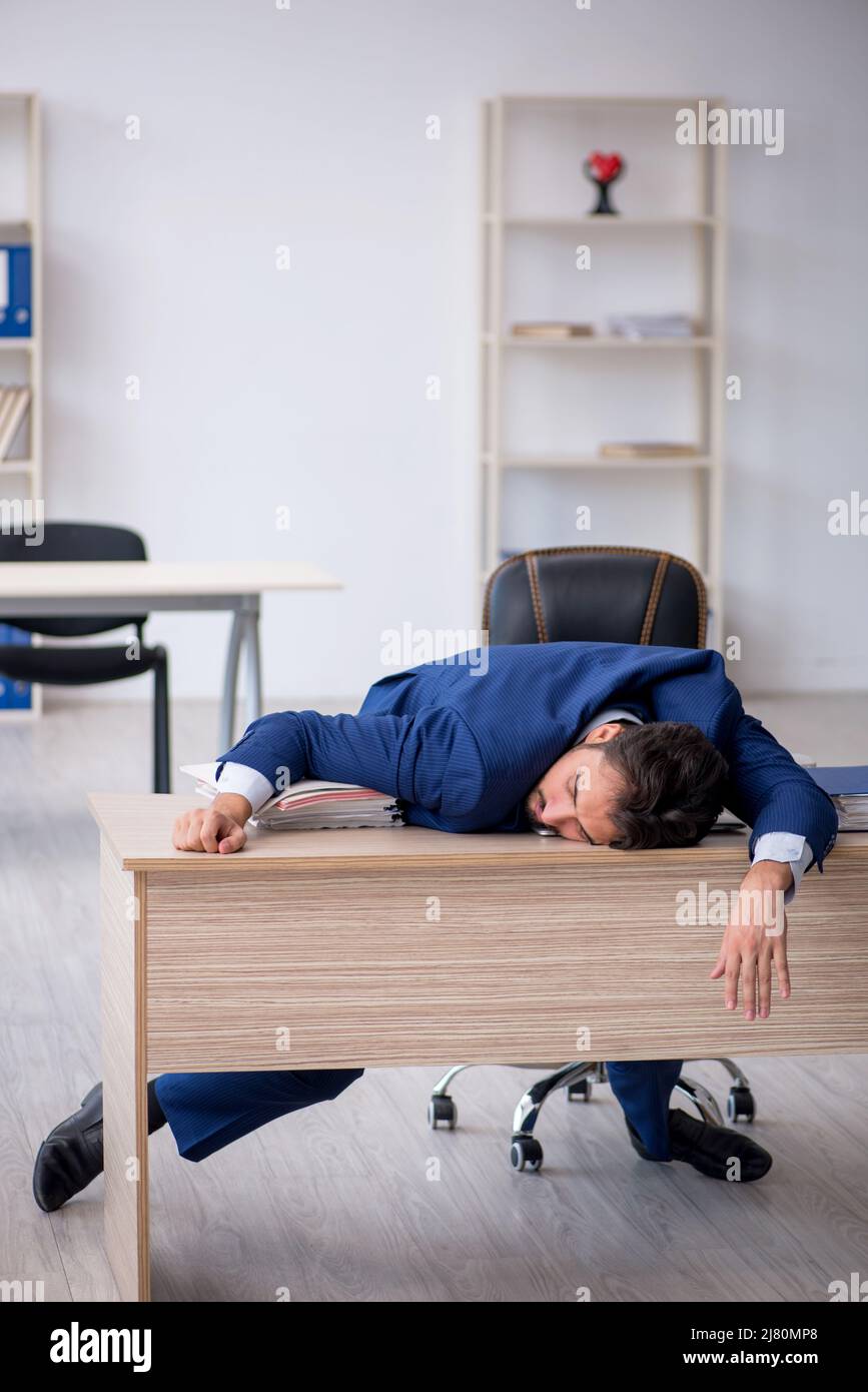 Young businessman employee extremely tired at workplace Stock Photo - Alamy