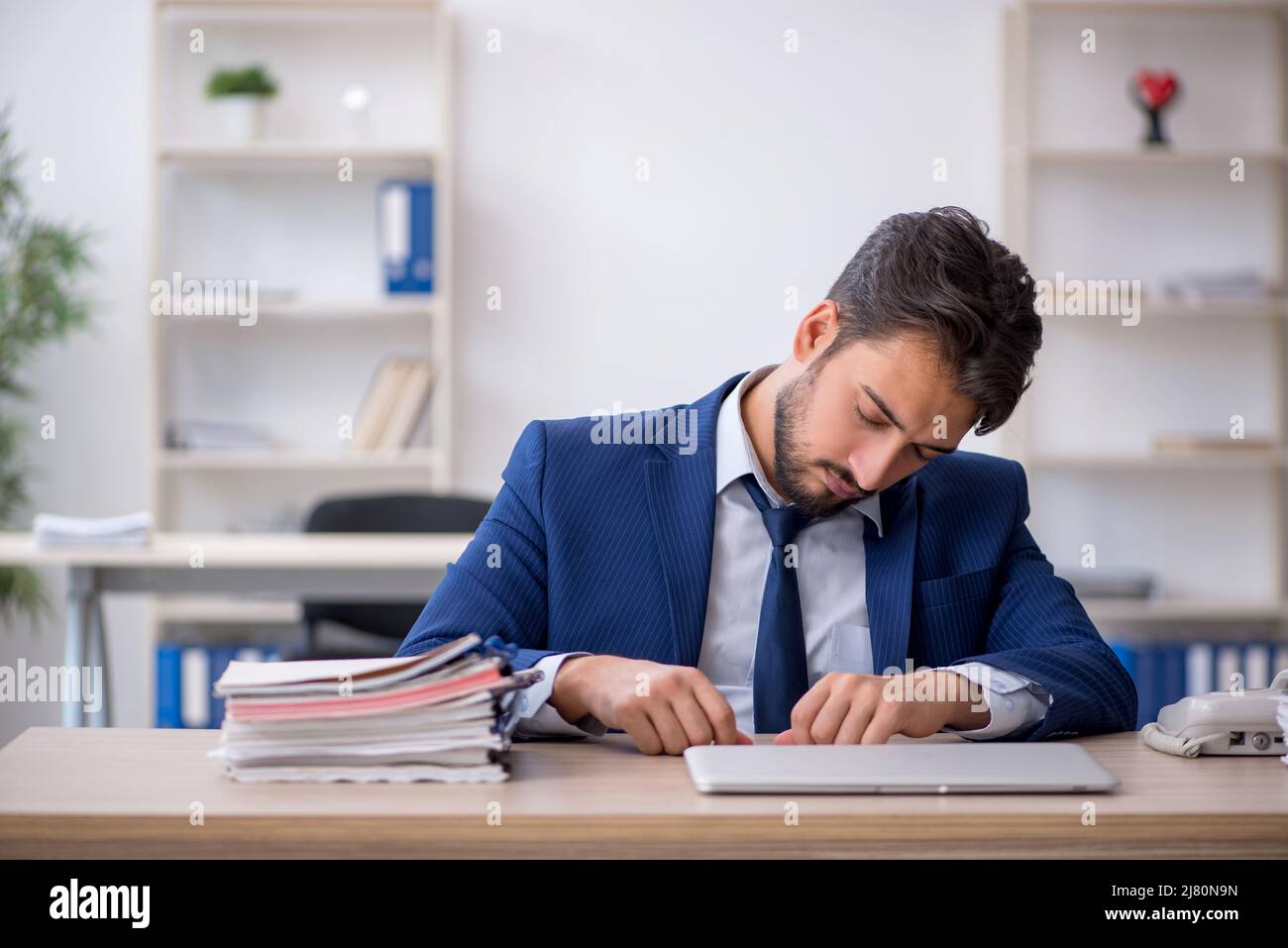 Young businessman employee extremely tired at workplace Stock Photo - Alamy