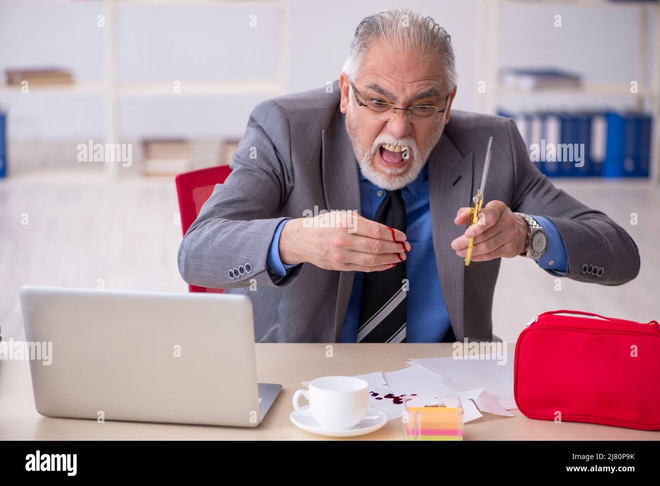 Old businessman employee cutting his hand at workplace Stock Photo - Alamy