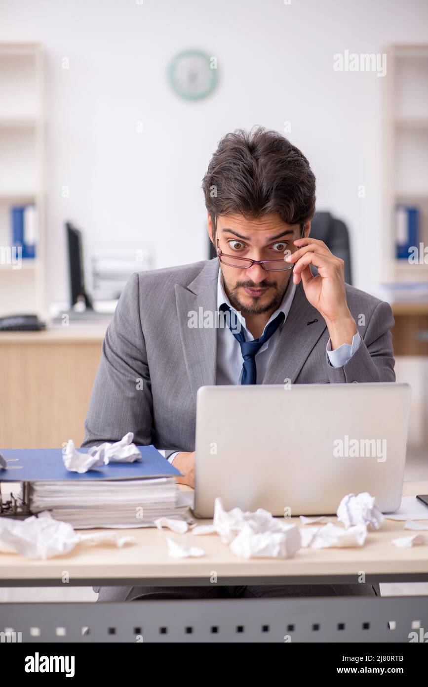 Young employee and too much work in the office Stock Photo - Alamy