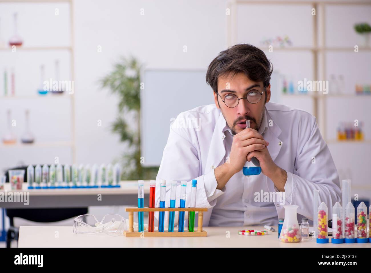 Young chemist in drugs synthesis concept Stock Photo - Alamy
