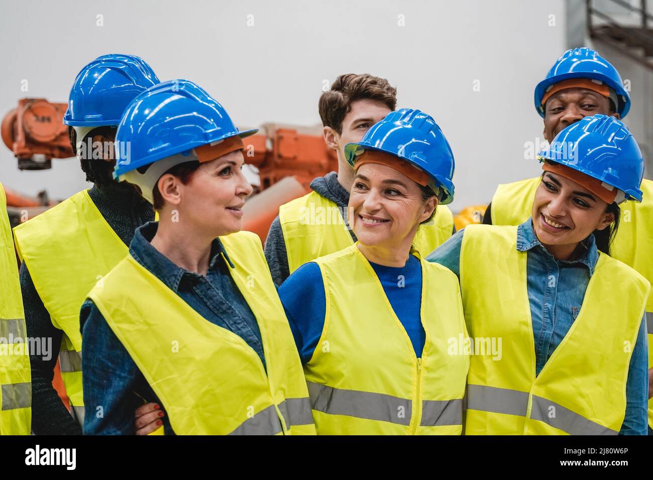 Multiethnic engineers working together inside automation and robotics ...