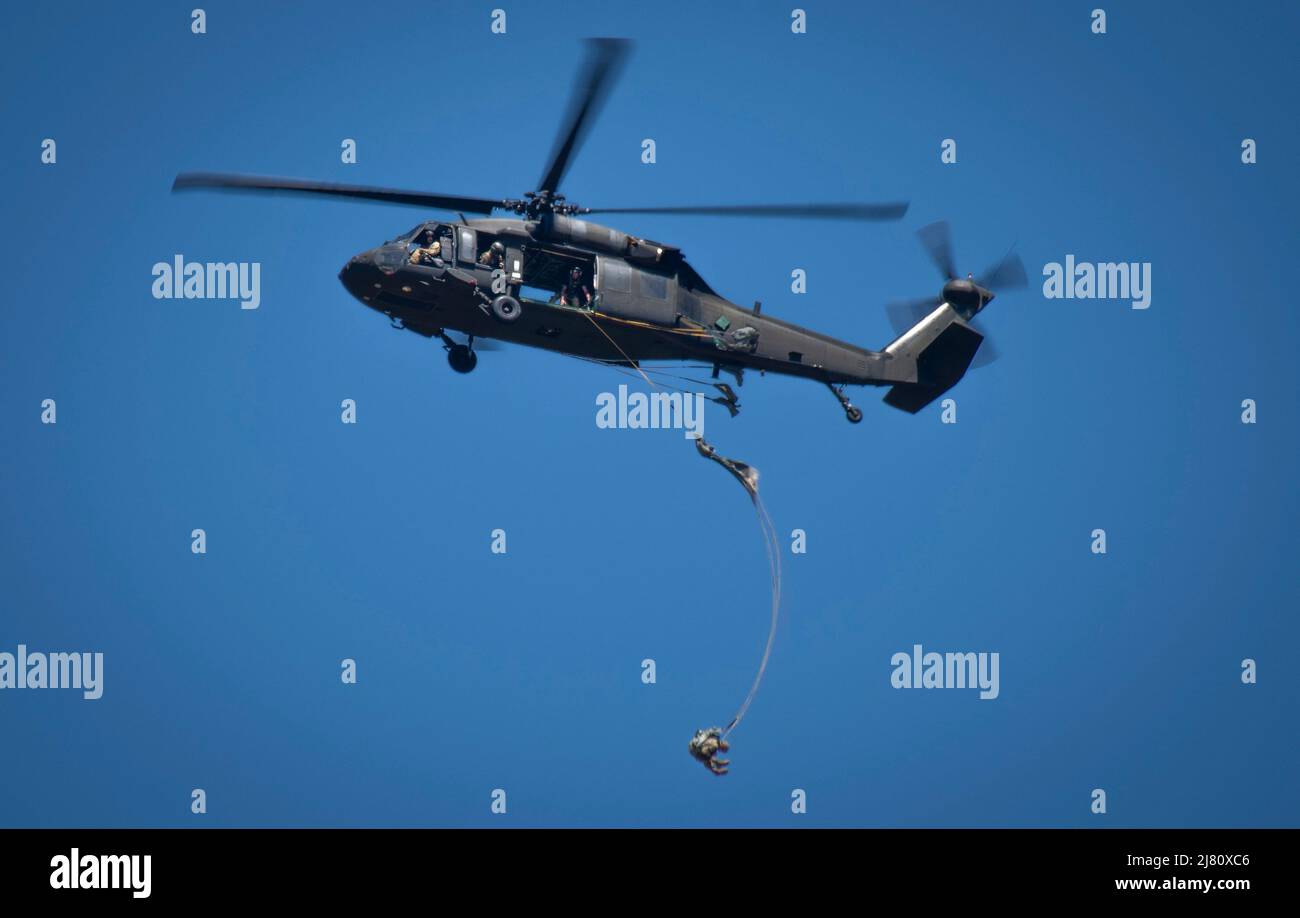 A parachuting Ranger jumps out of an Army Blackhawk helicopter at the ...