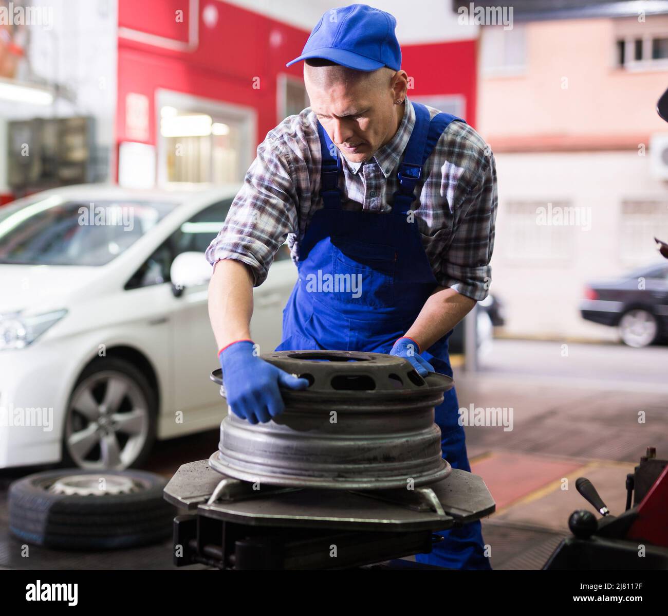Professional american сar mechanic changing the wheel Stock Photo - Alamy