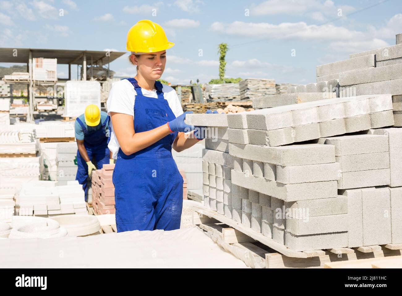Worker stacking paving slabs in warehouse of building materials Stock ...