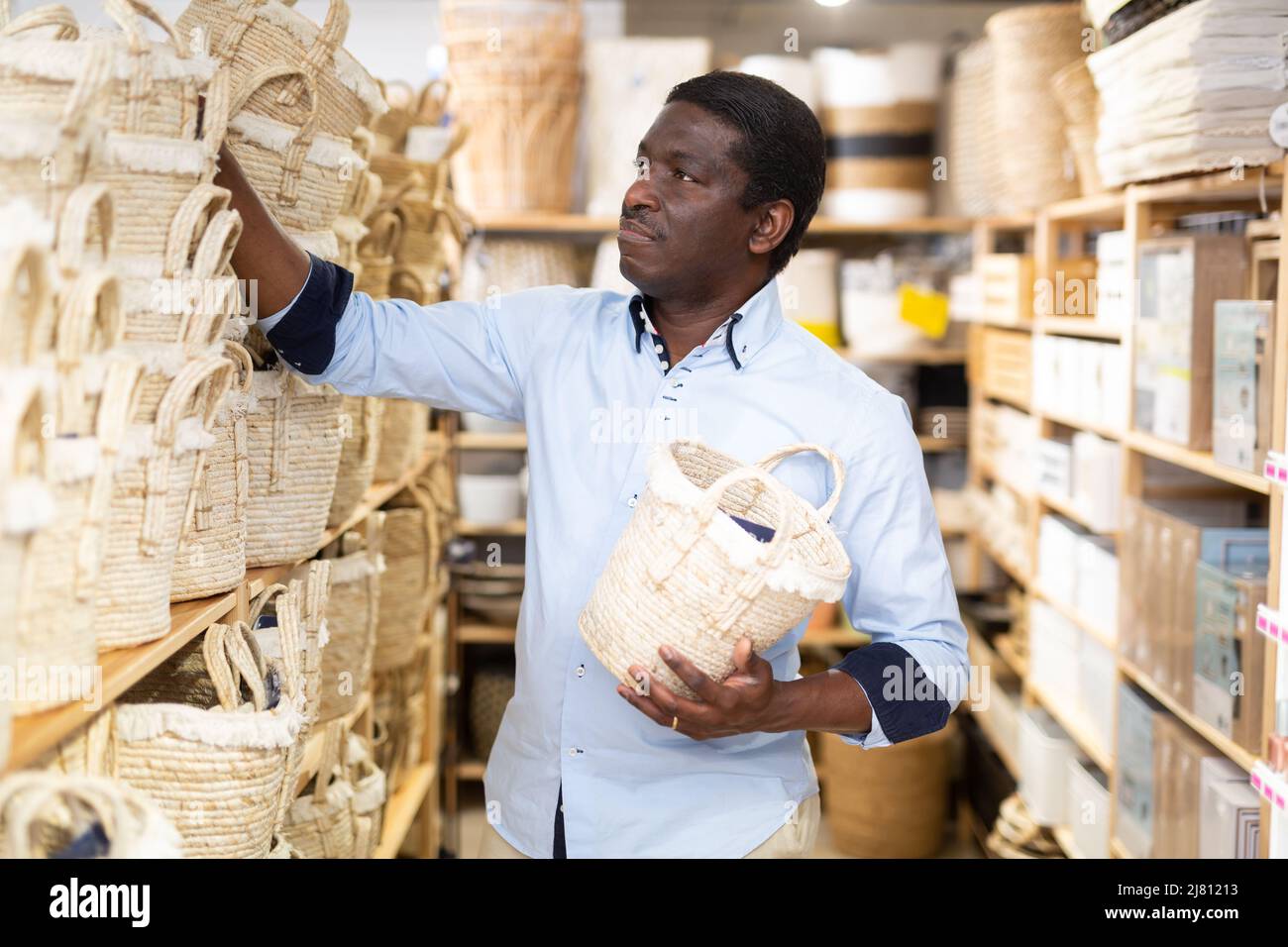 Man choosing wicker basket at hardware store Stock Photo - Alamy