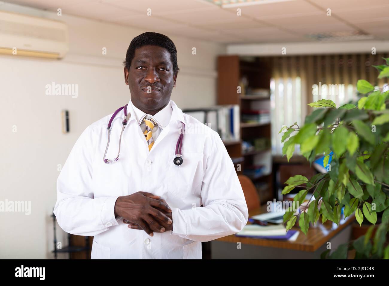 African american man doctor standing in medical office making welcoming ...