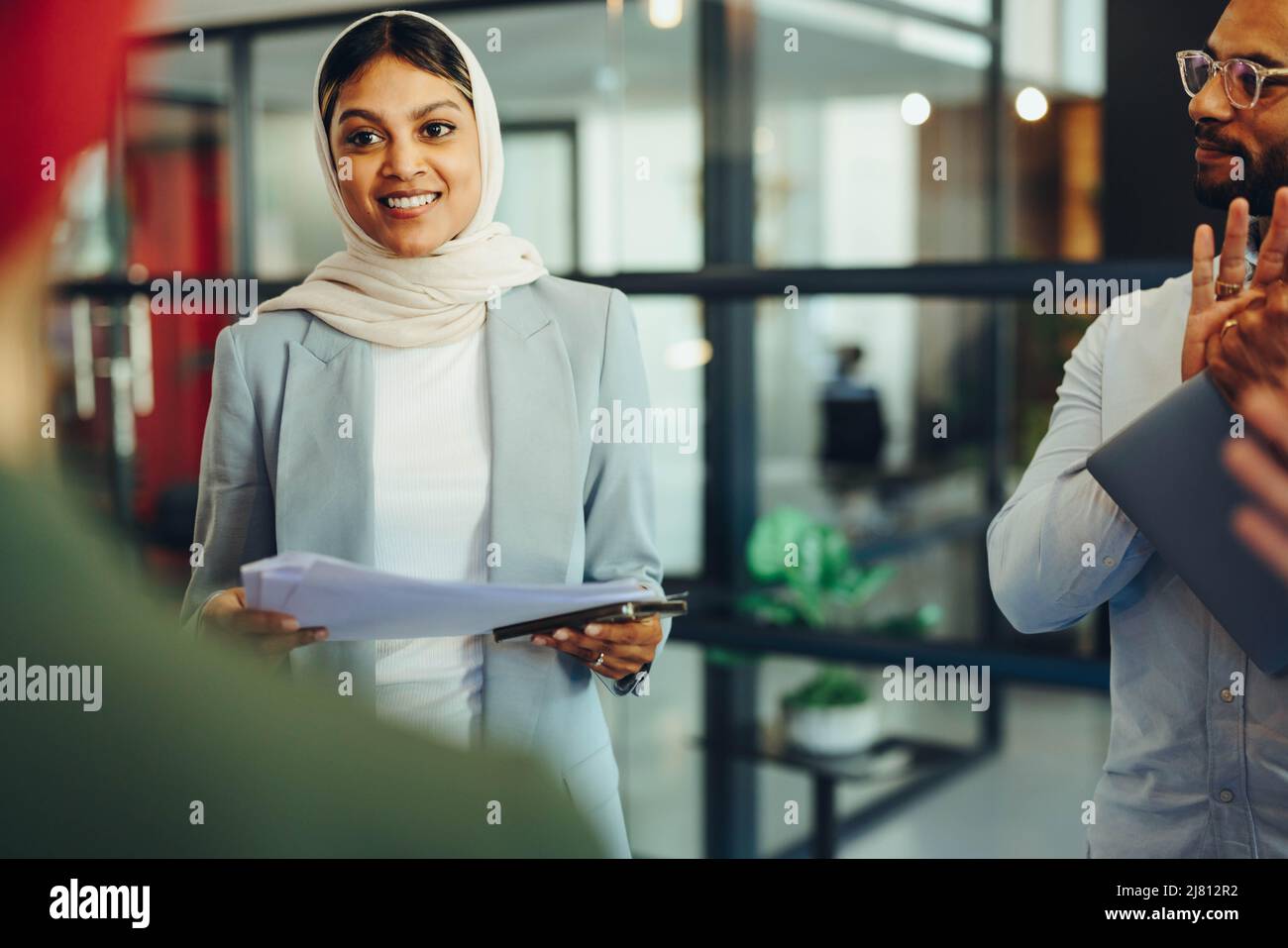 Cheerful Muslim manager holding a business meeting with her colleagues ...