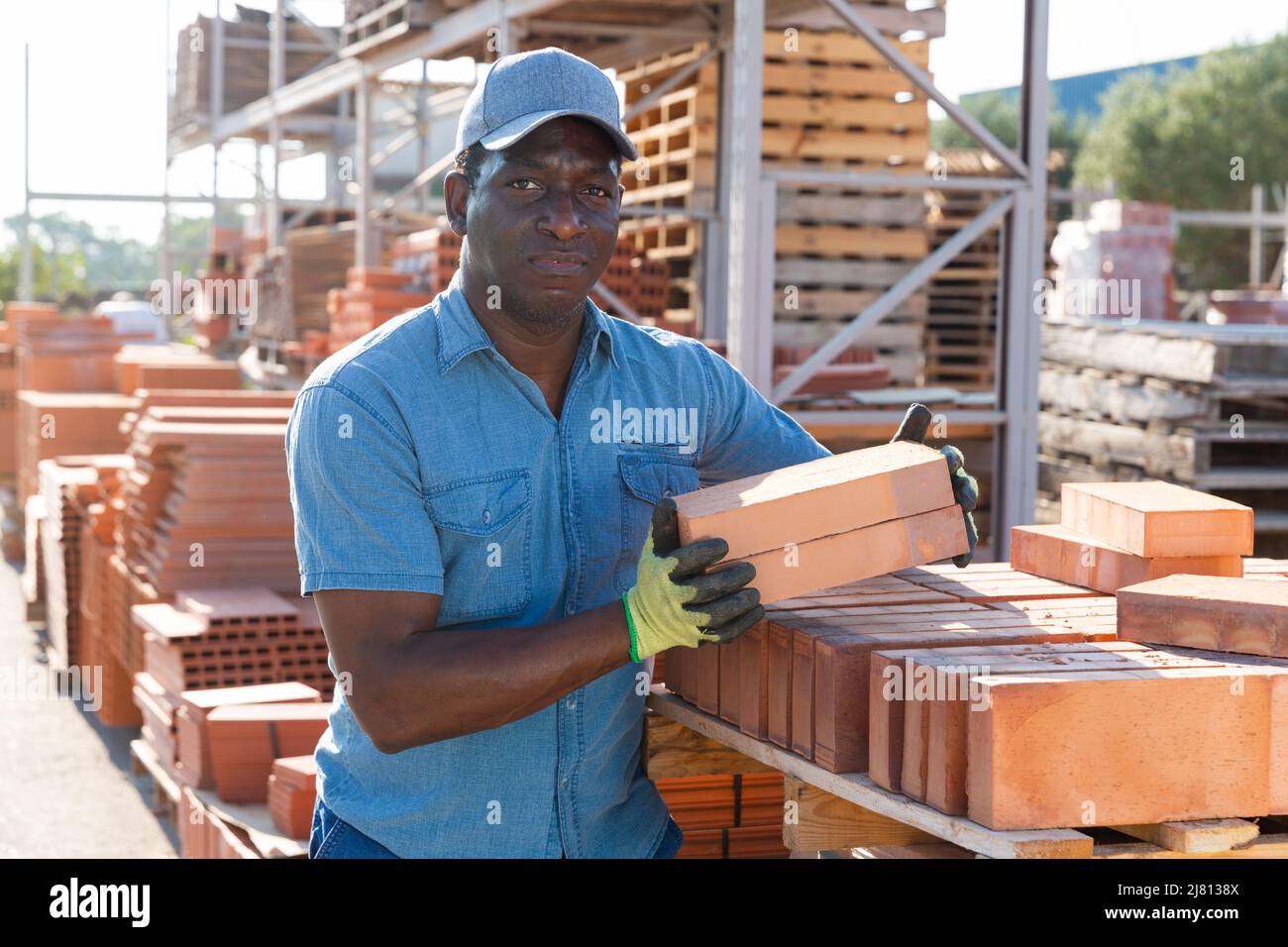 Worker stacking bricks in warehouse of building materials clpseup Stock ...