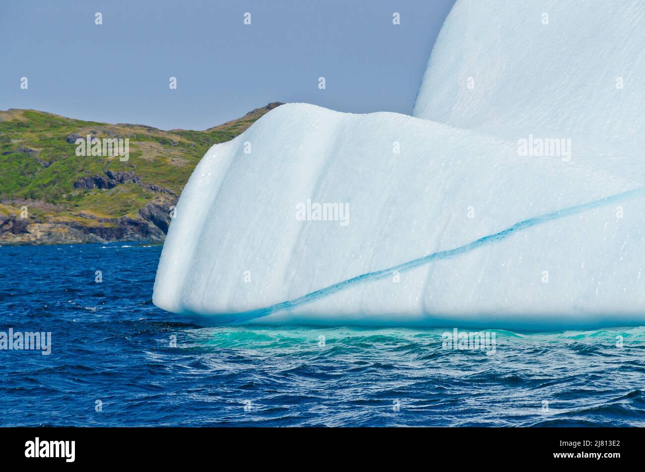Bright white iceberg on dark water and rock background Stock Photo - Alamy