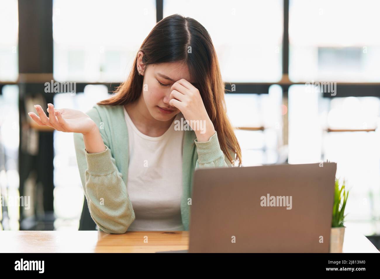 Frustrated young woman have problem while sitting at her working place ...