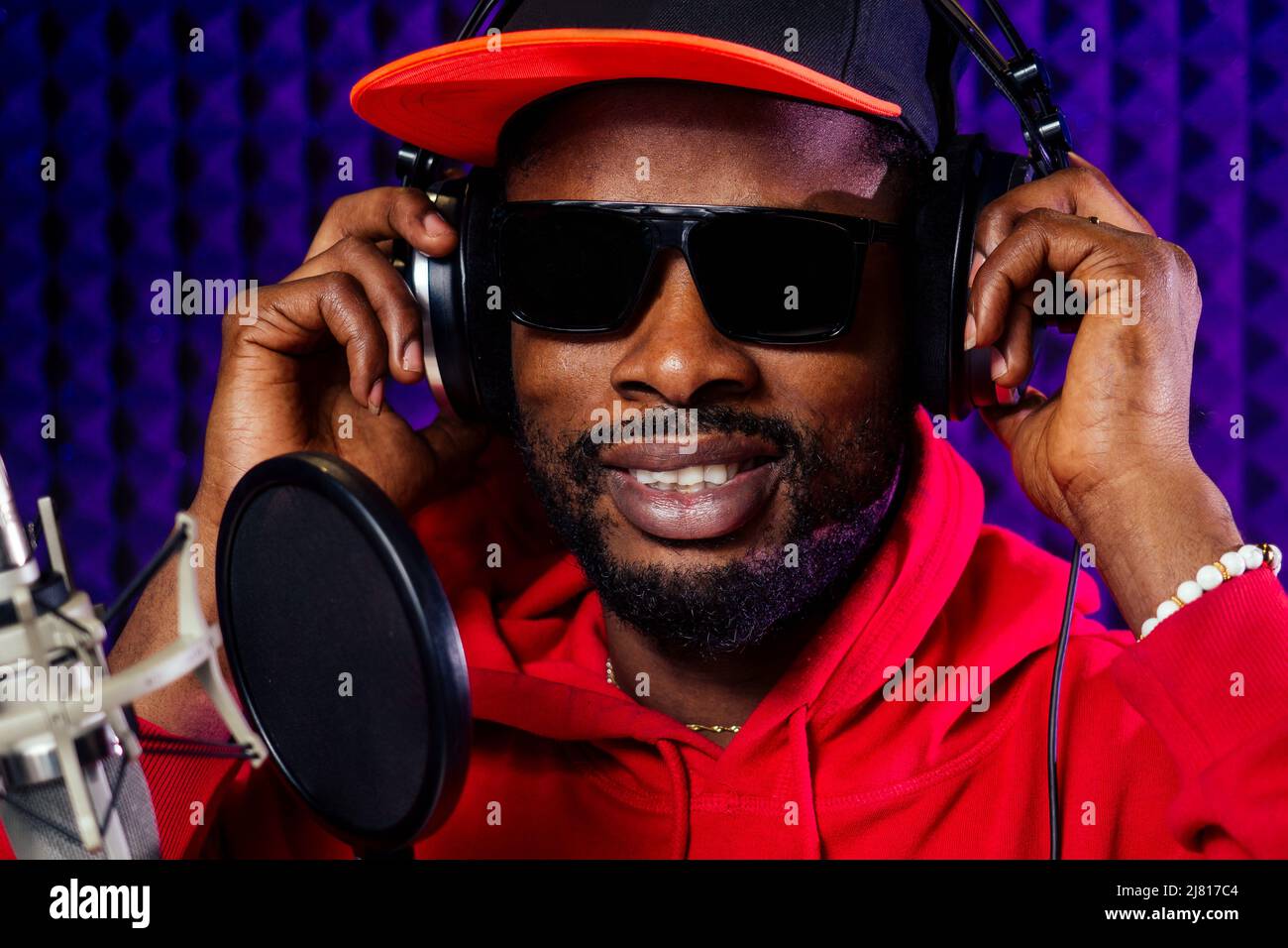 afro american man headphones in a cap and a hood sunglasses recording ...