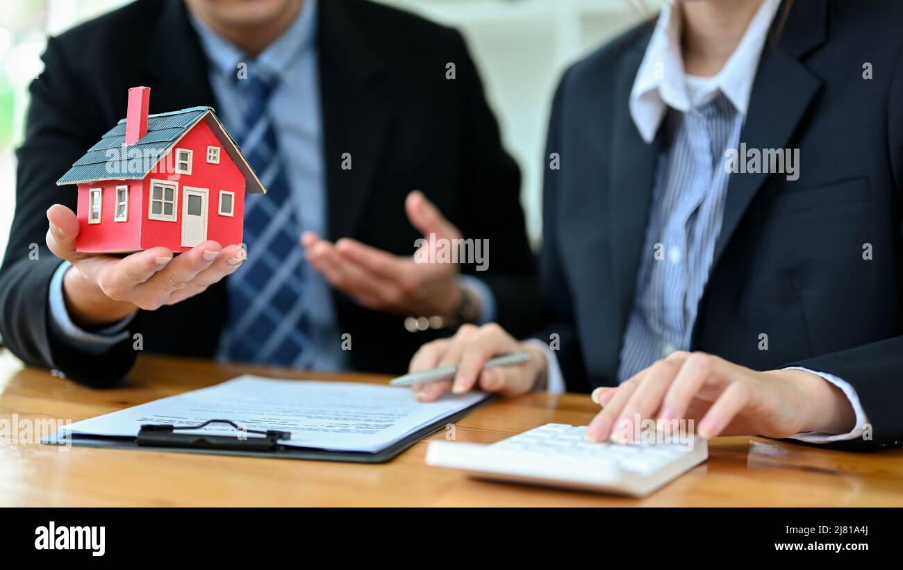 Successful male real estate agent presenting his the great offer deal ...